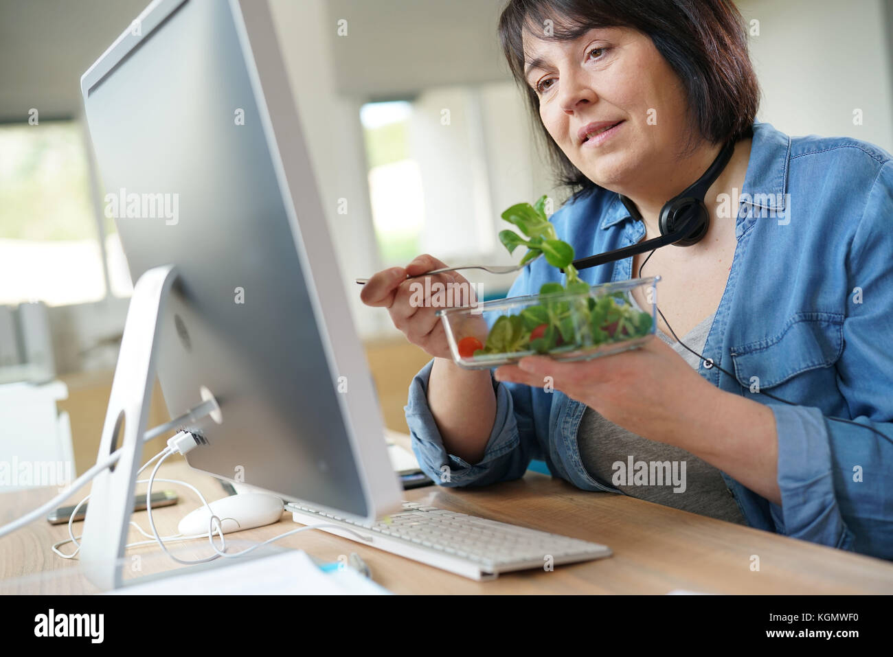 Telemarketing operator having lunch at work Stock Photo - Alamy