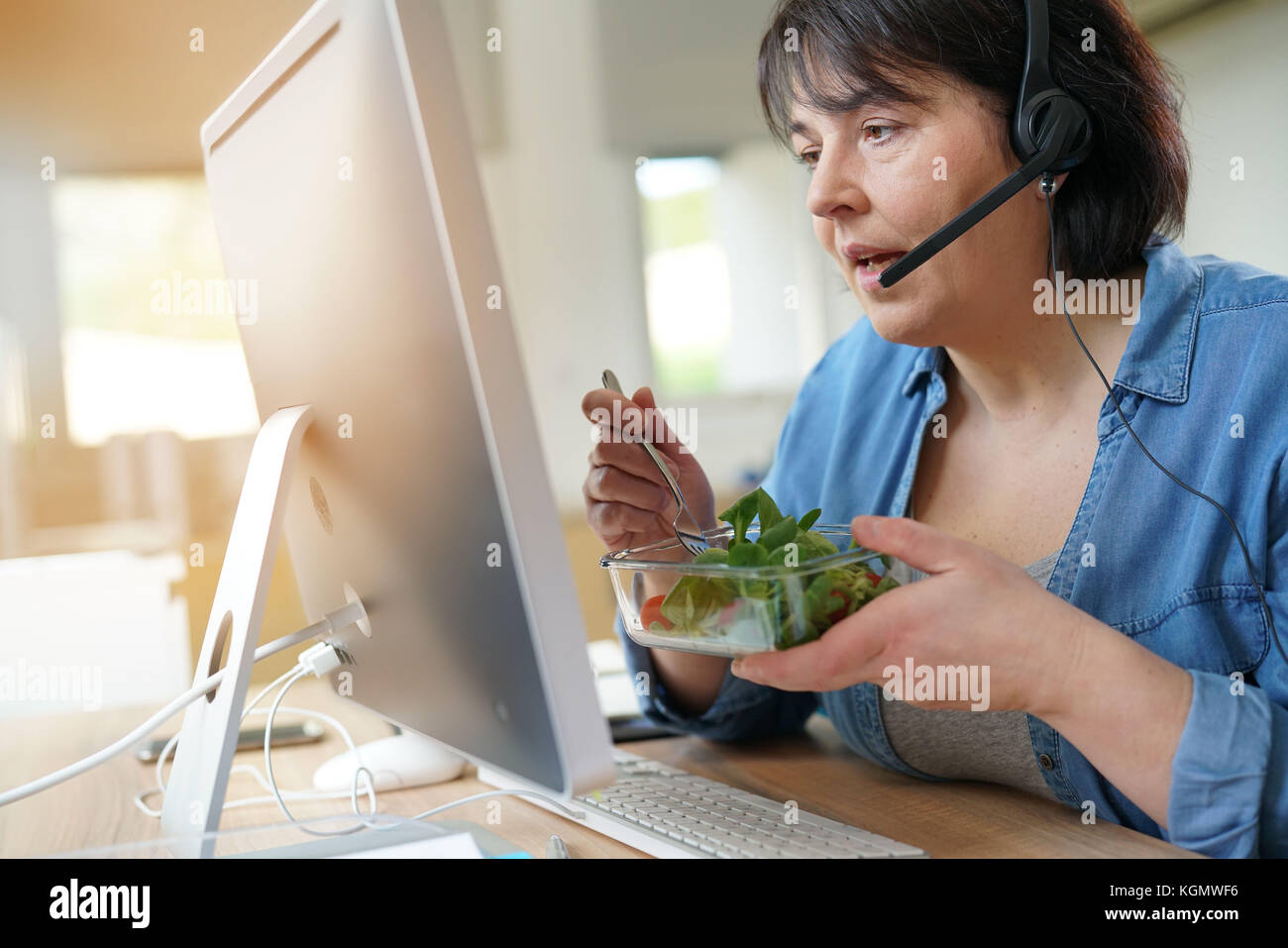 Telemarketing operator having lunch at work Stock Photo - Alamy