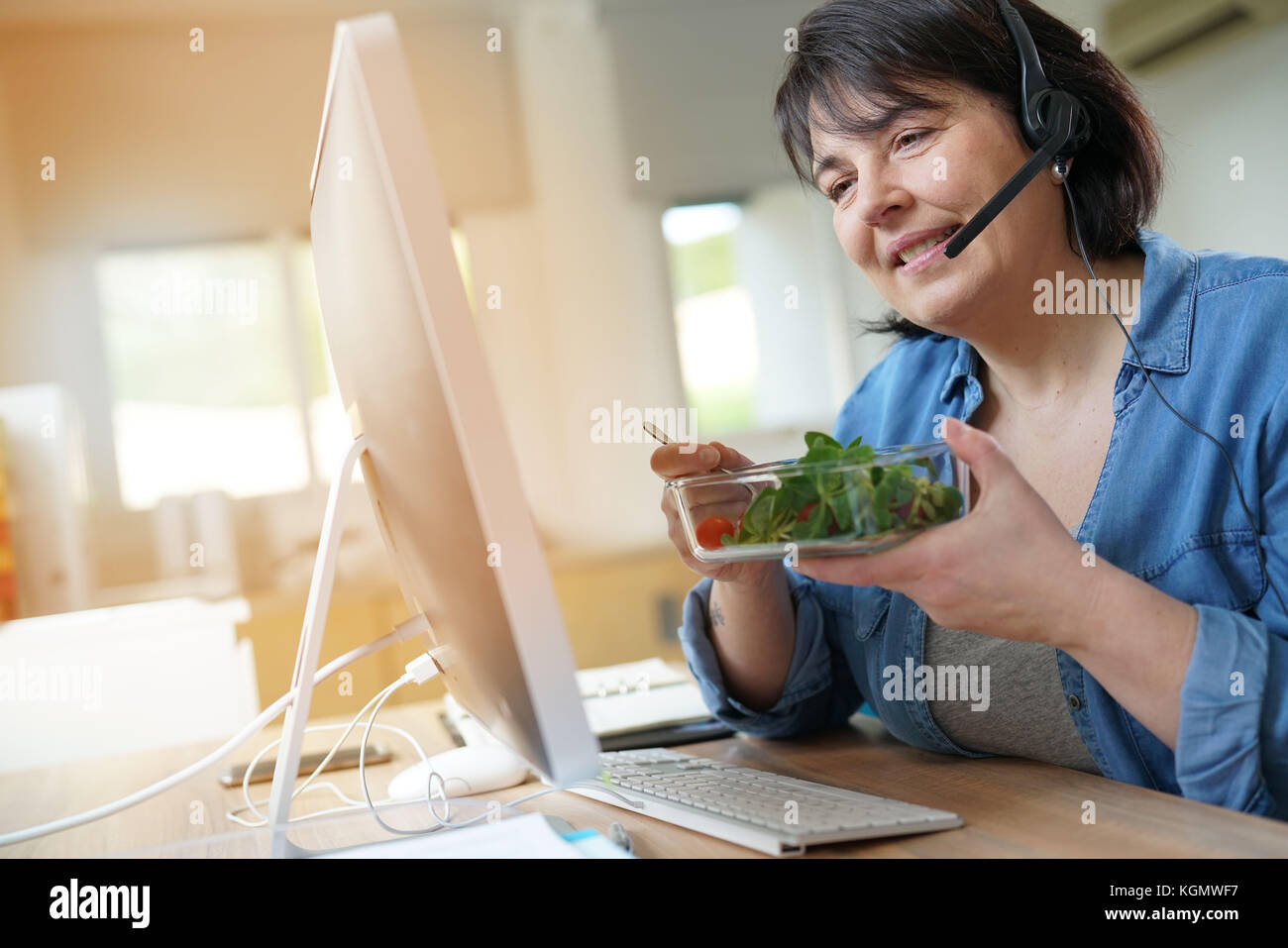 Telemarketing operator having lunch at work Stock Photo - Alamy