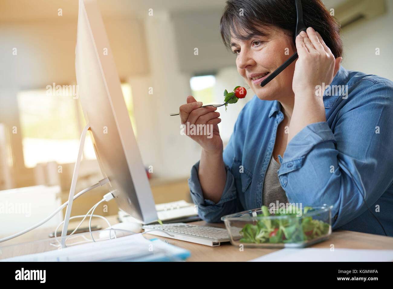 Telemarketing operator having lunch at work Stock Photo - Alamy