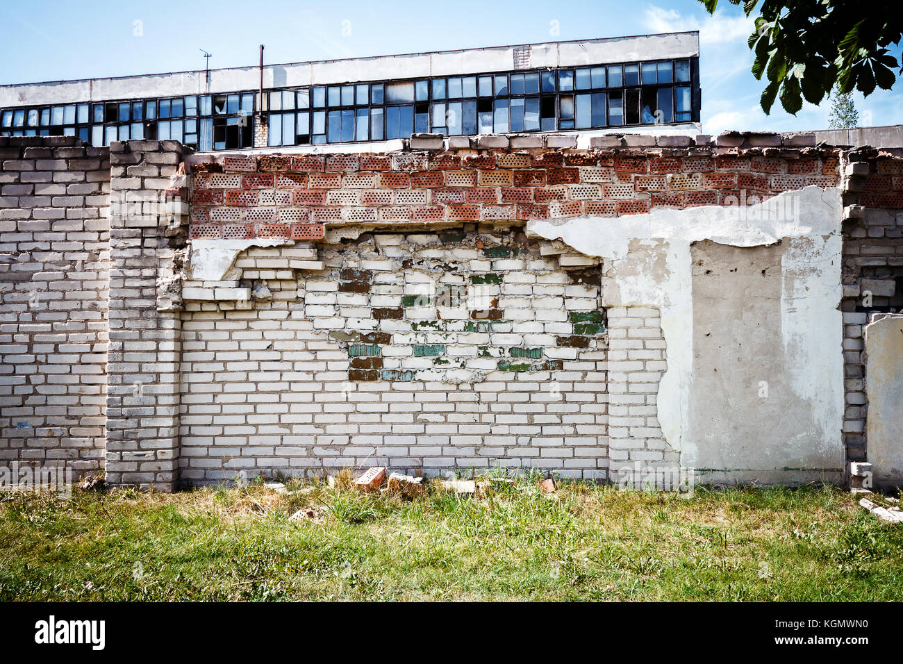 Abandoned factory behind old brick fence on a sunny day Stock Photo - Alamy