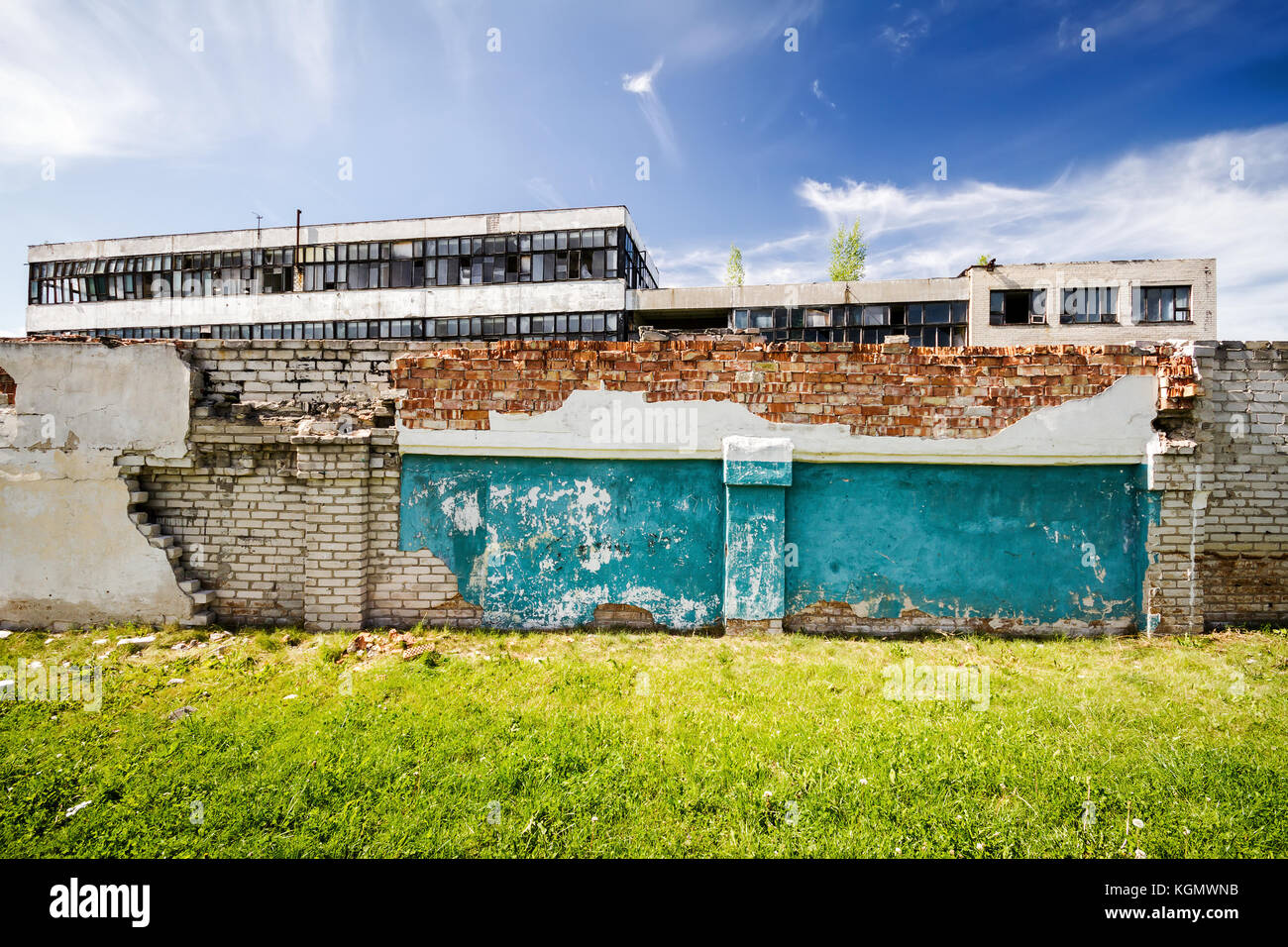 Abandoned factory behind old brick fence on a sunny day Stock Photo - Alamy