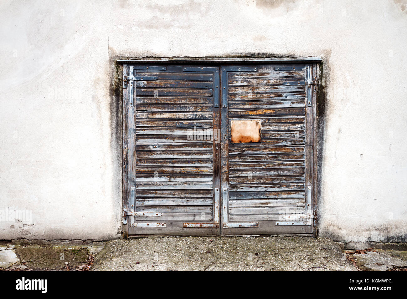 Old wooden gate in grungy white wall. Architecture detail background ...