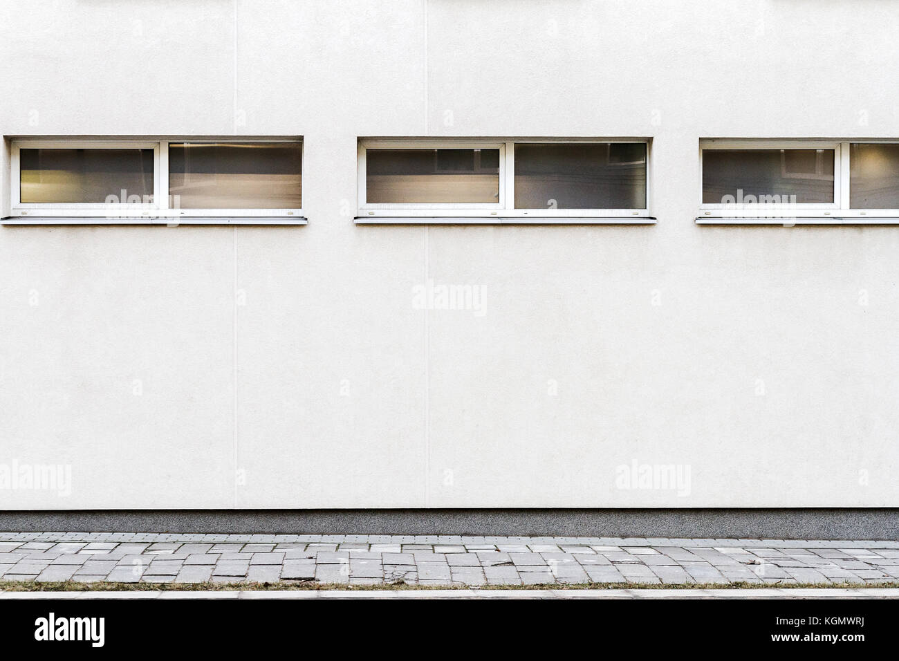 Modern white street wall with a row of windows Stock Photo - Alamy