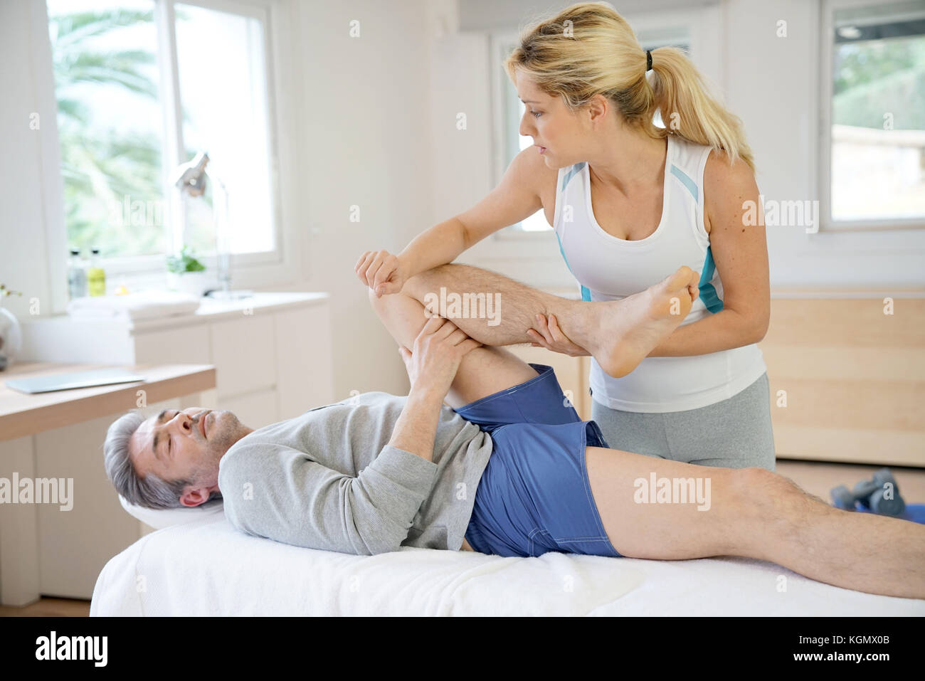 Physiotherapist stretching patient's leg Stock Photo - Alamy