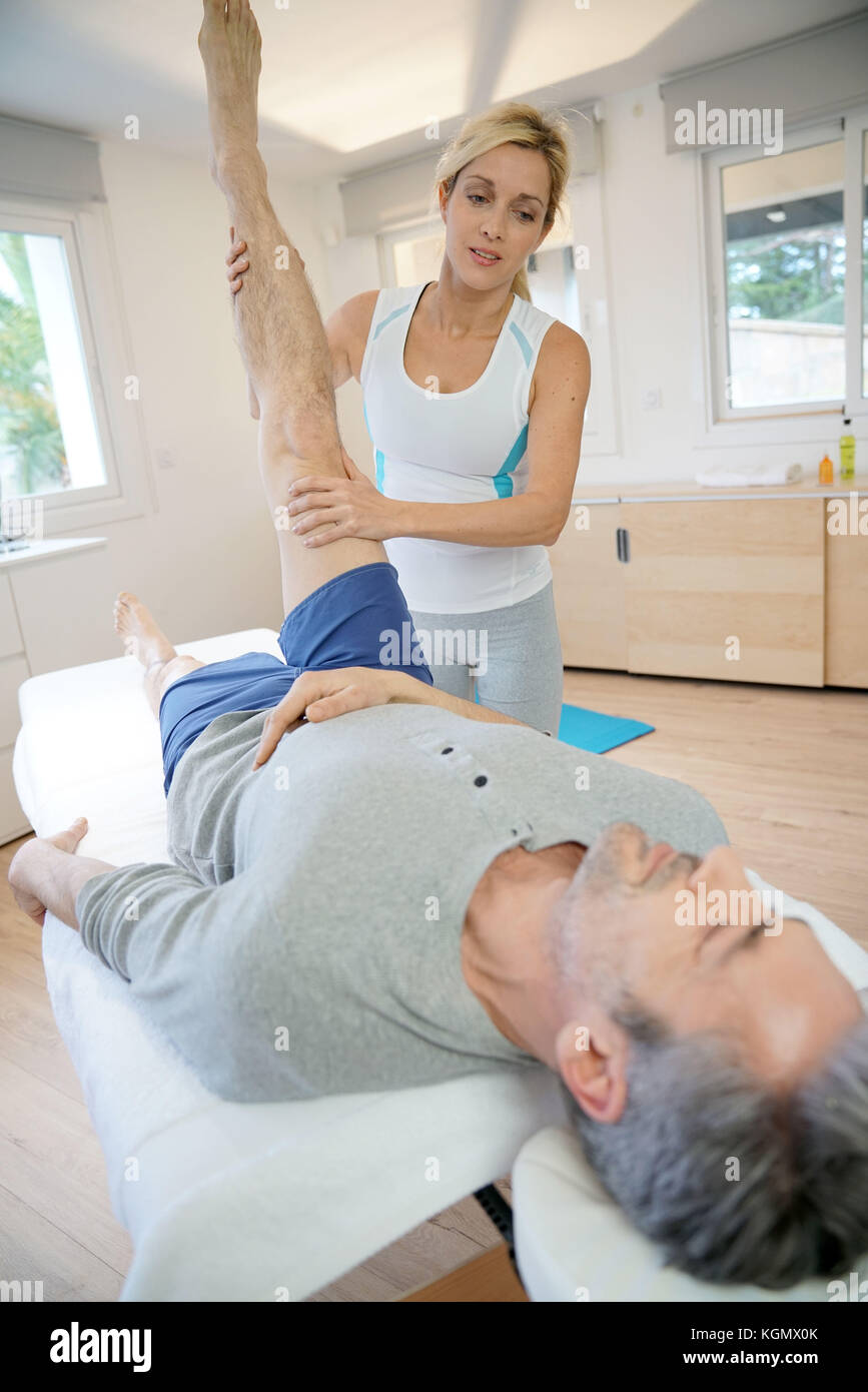 Physiotherapist stretching patient's leg Stock Photo - Alamy