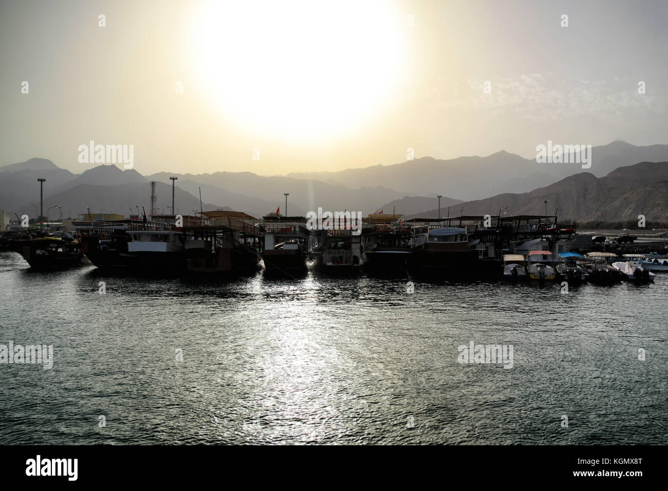 View on a boats docked at the little harbour in Oman, beautiful sunset ...