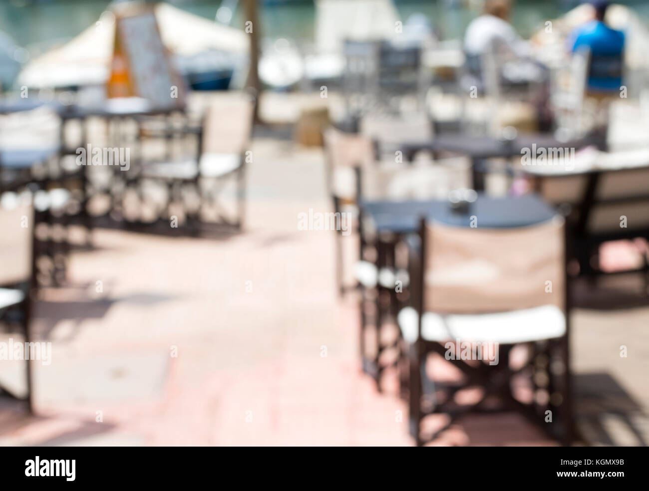 Background of blurred cafe on street of city. Tables and chairs outside ...