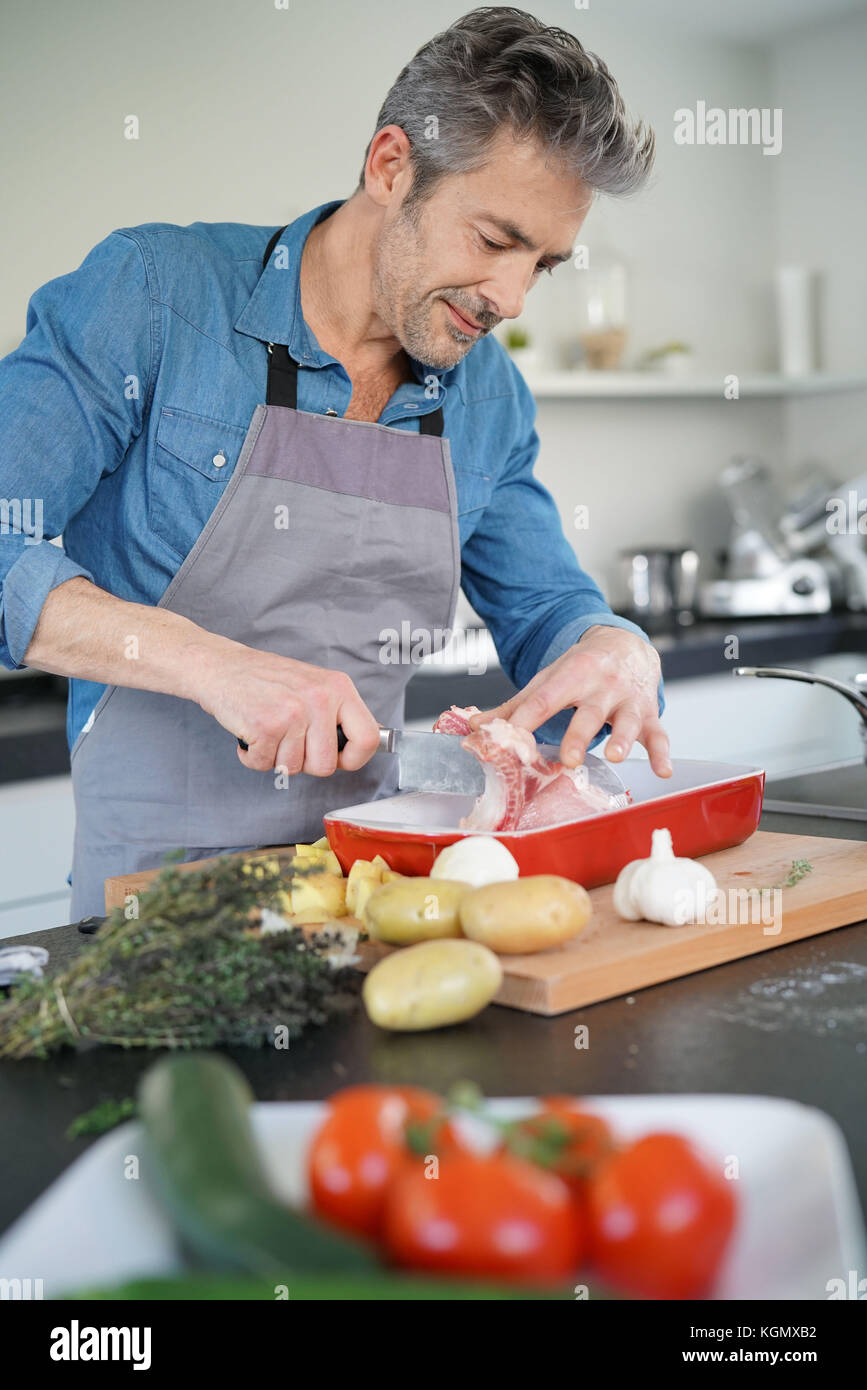 Mature man in kitchen cooking dish for dinner Stock Photo - Alamy