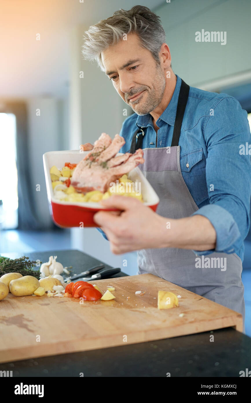 Mature man in kitchen cooking dish for dinner Stock Photo - Alamy
