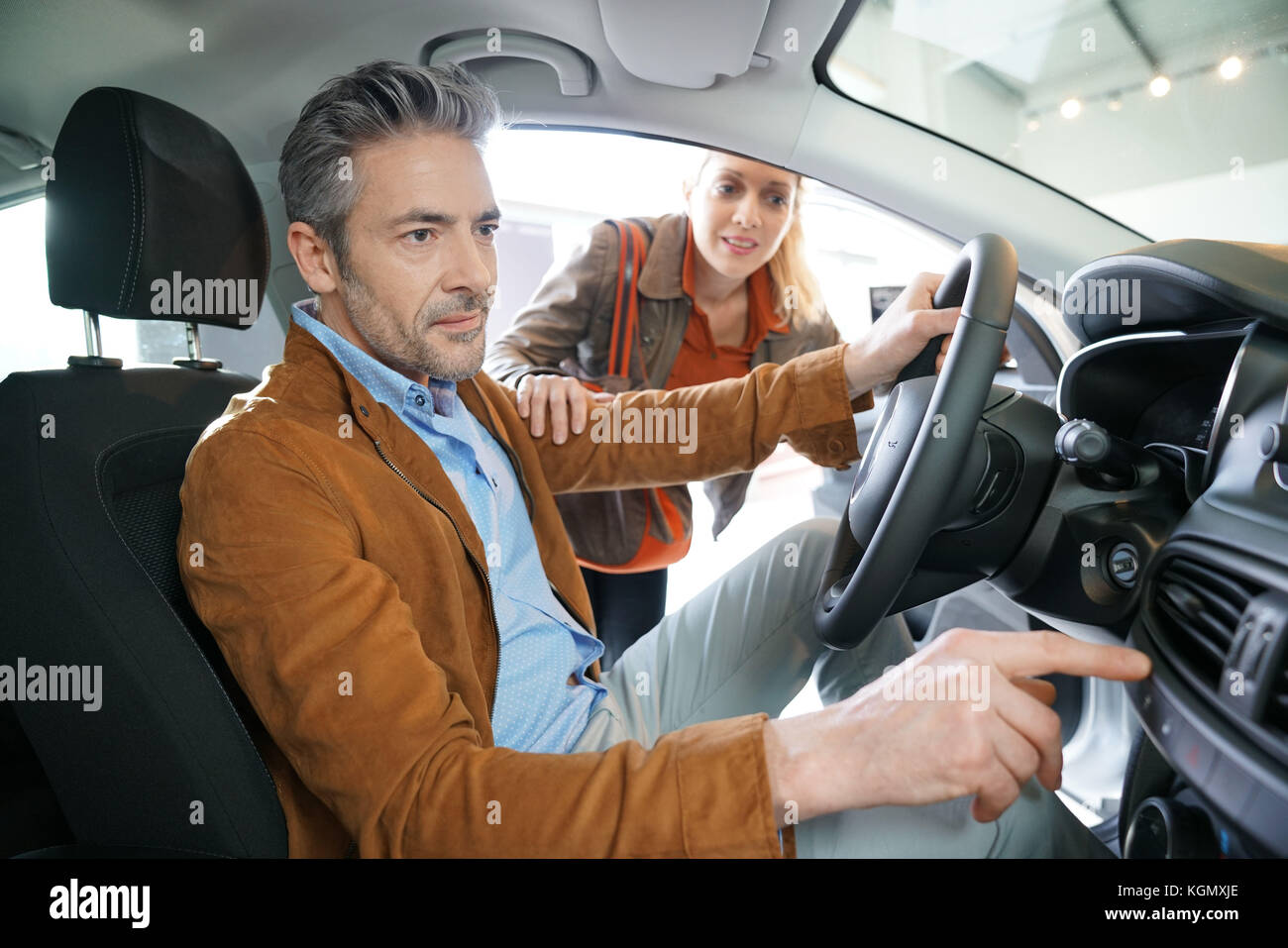 Man sitting inside vehicle in car dealership Stock Photo - Alamy