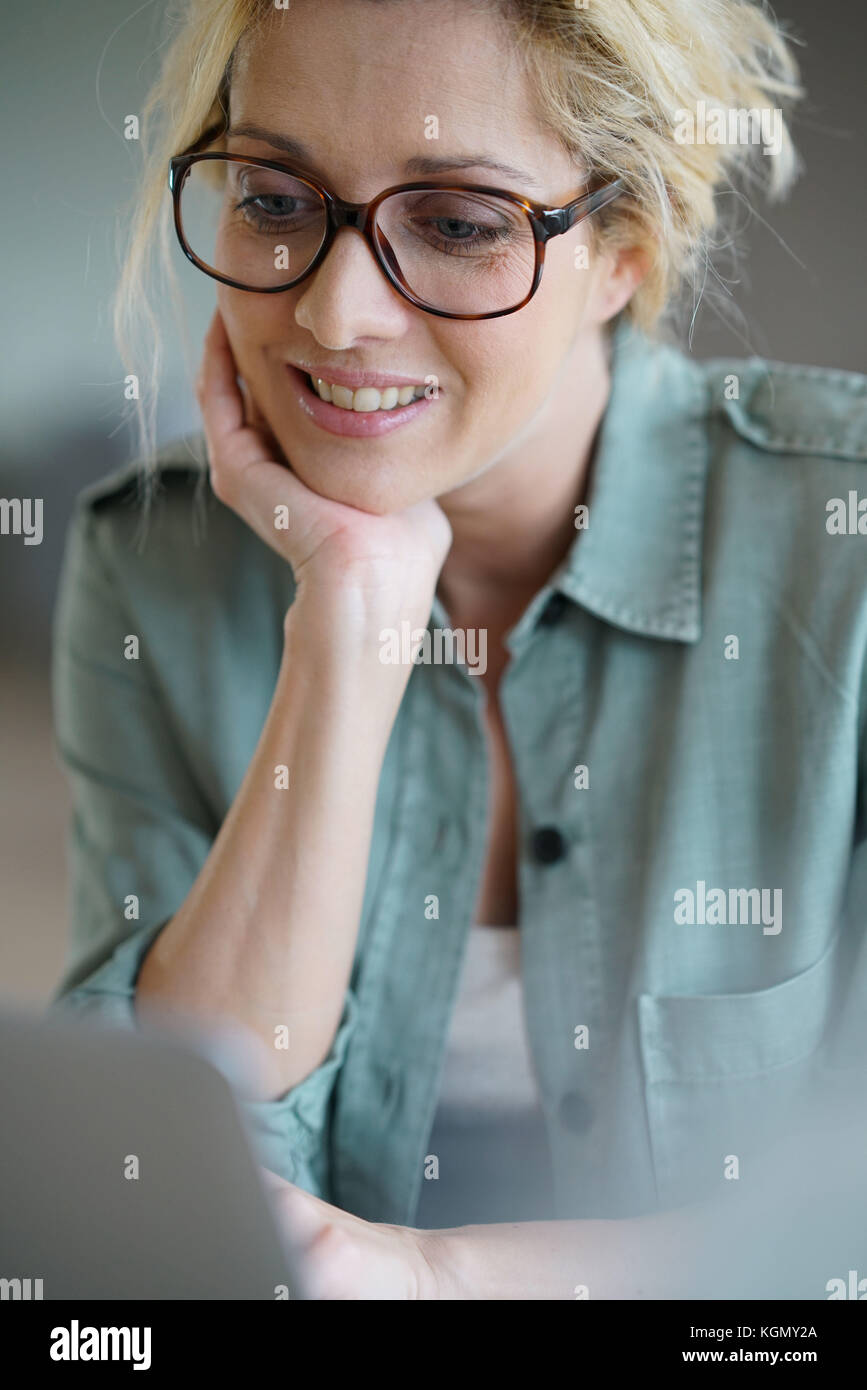 Portrait of blond woman working from home on laptop computer Stock ...