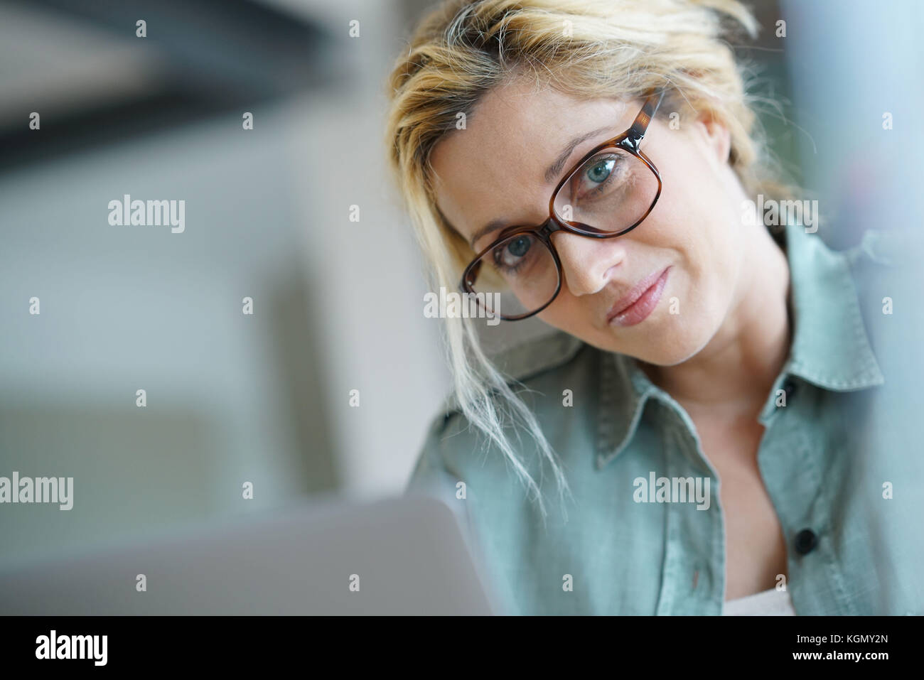 Portrait of blond woman working from home on laptop computer Stock ...