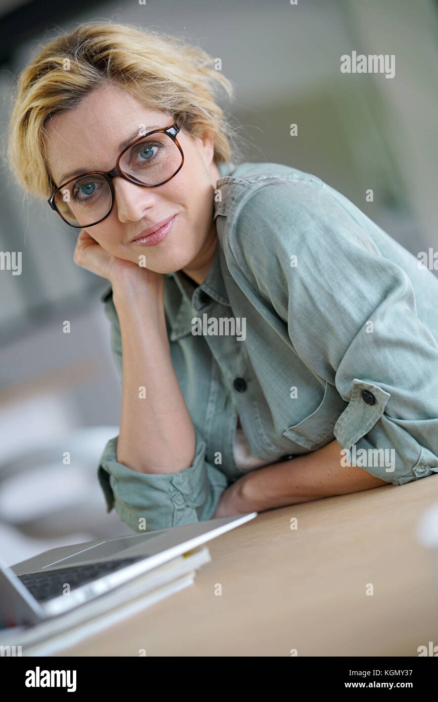 Portrait of blond woman working from home on laptop computer Stock ...