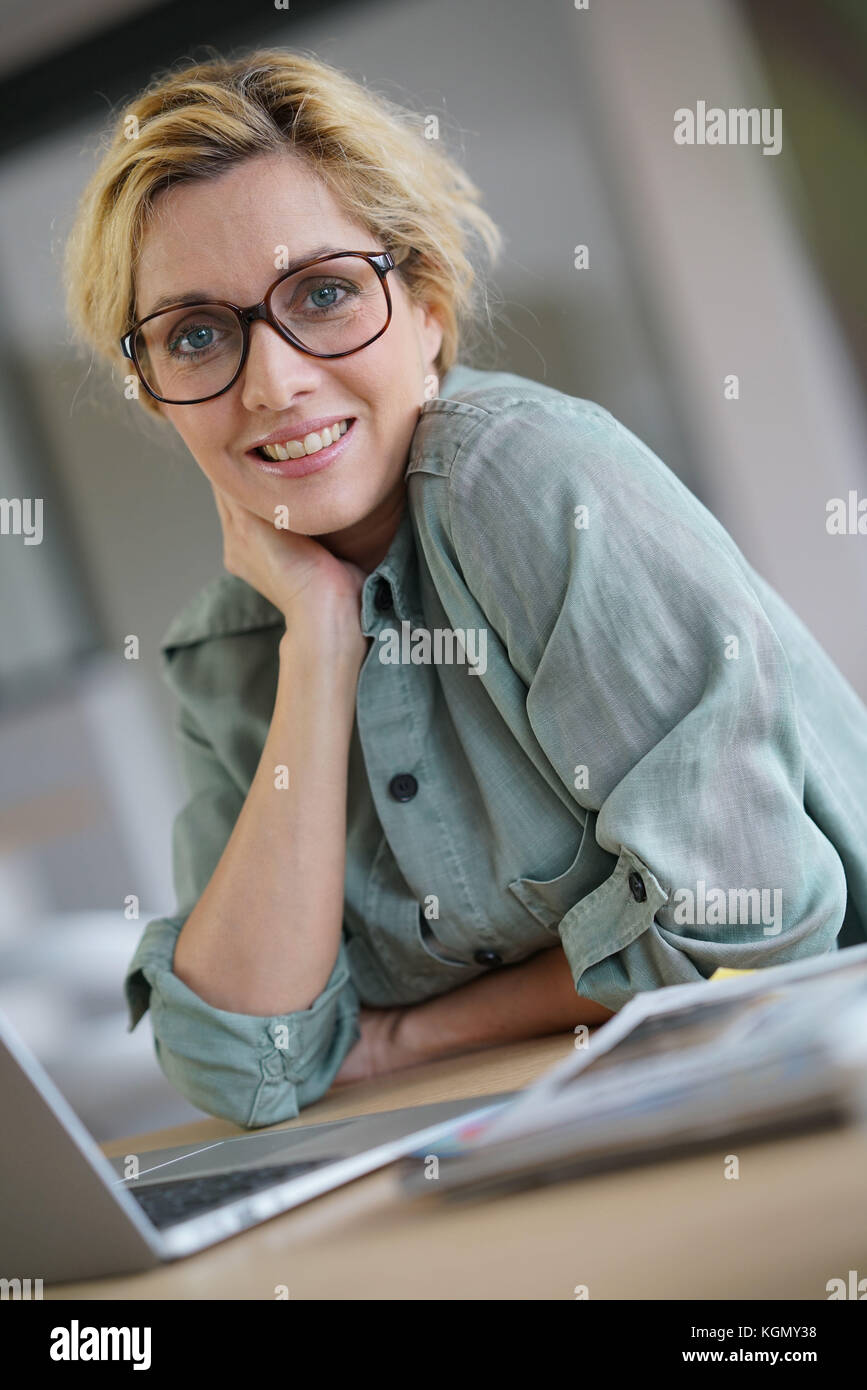 Portrait of blond woman working from home on laptop computer Stock ...