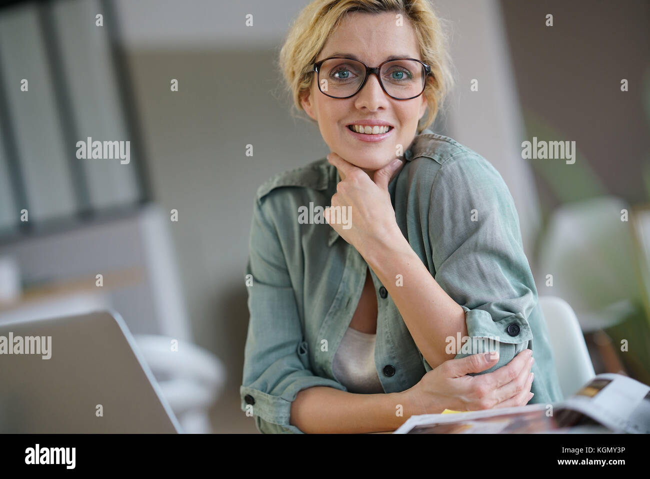 Portrait of blond woman working from home on laptop computer Stock ...