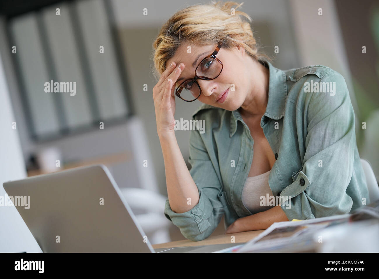 Portrait of blond woman working from home on laptop computer Stock ...