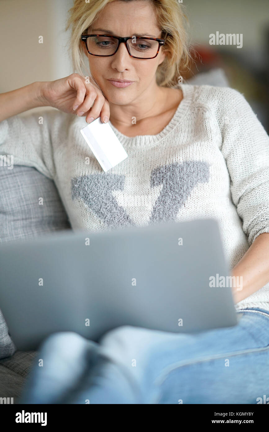 Middle-aged woman at home buying on internet with credit card Stock ...