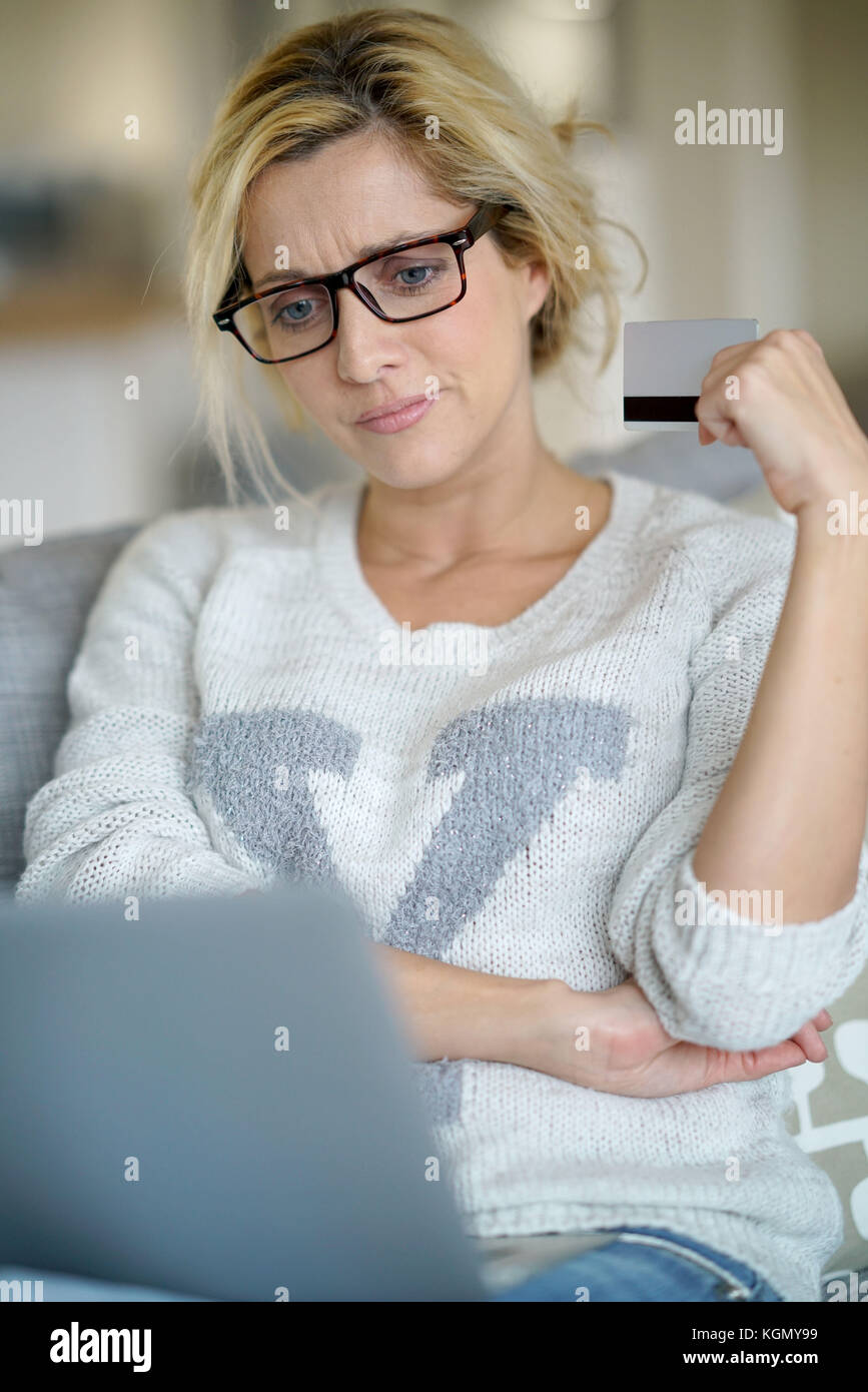 Middle-aged woman at home buying on internet with credit card Stock ...