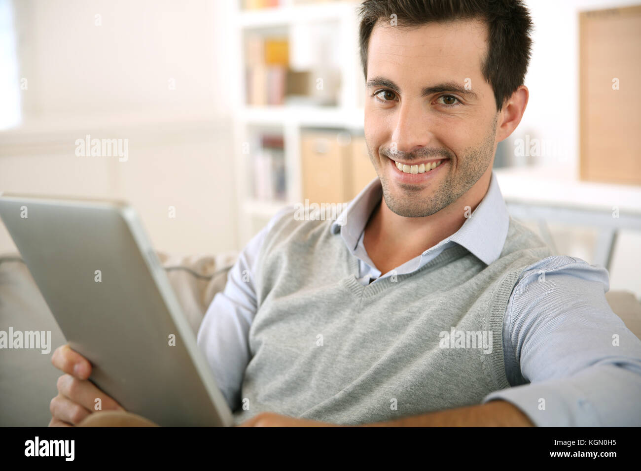 Smiling man websurfing on internet with tablet Stock Photo - Alamy