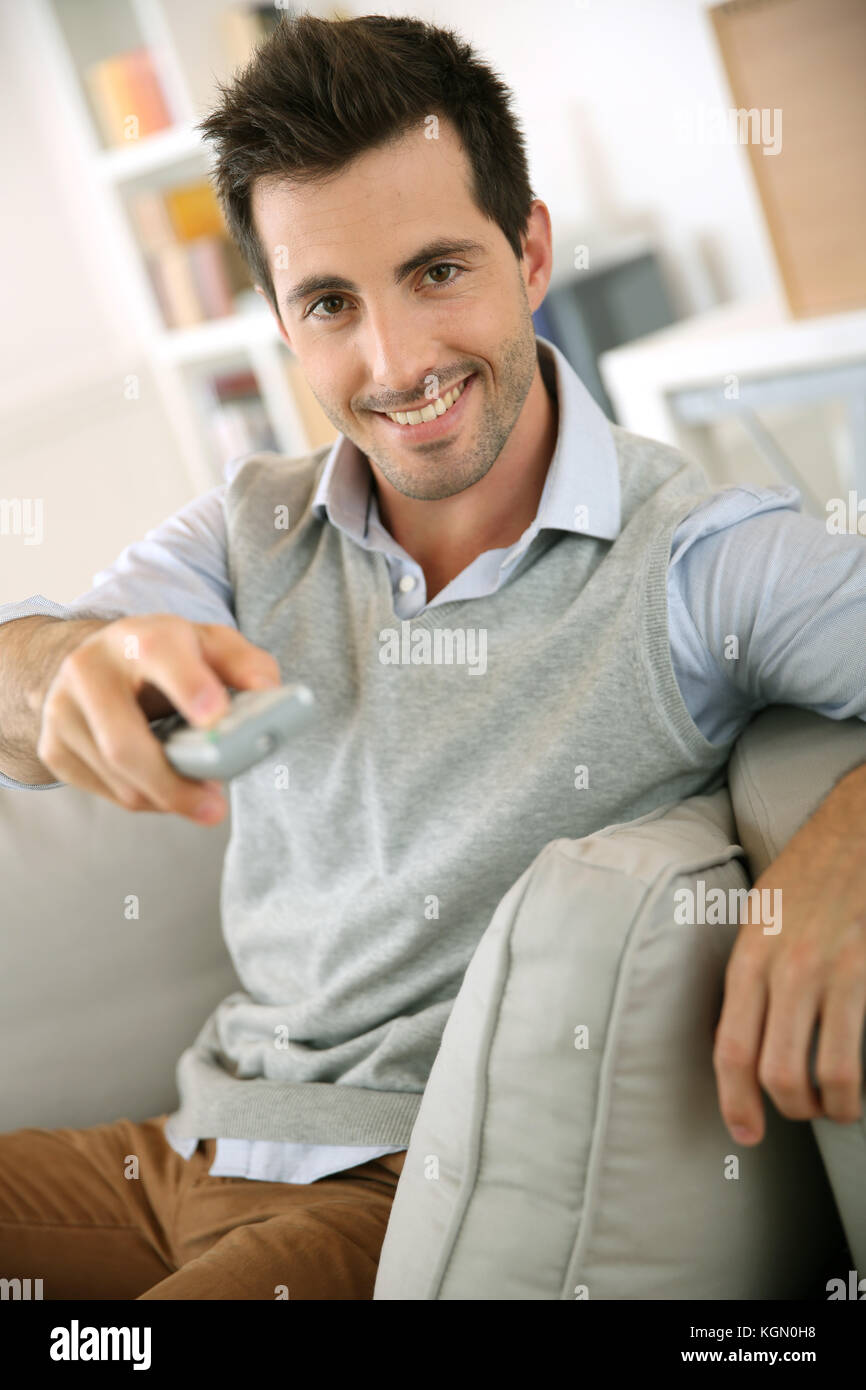 Smiling young man watching tv Stock Photo - Alamy