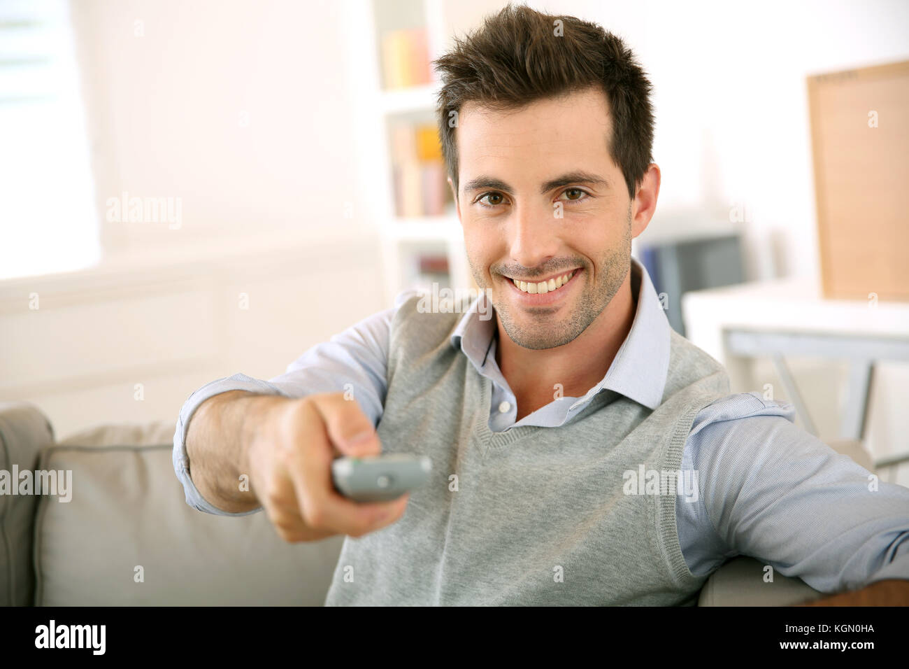 Smiling young man watching tv Stock Photo - Alamy