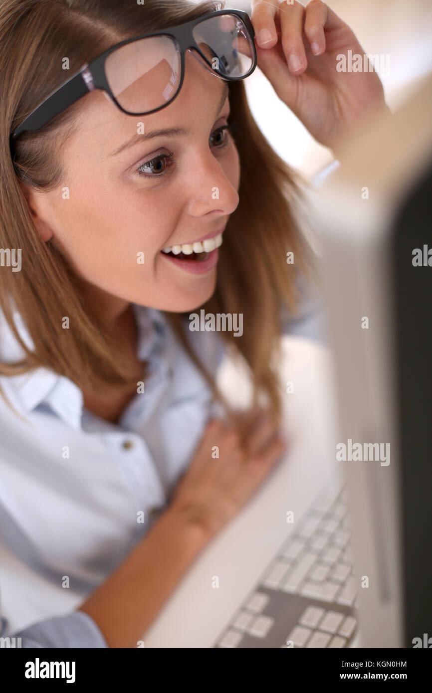 Woman looking at computer screen in office Stock Photo - Alamy