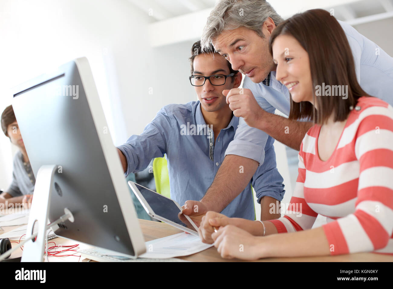Teacher with group of students in class Stock Photo - Alamy