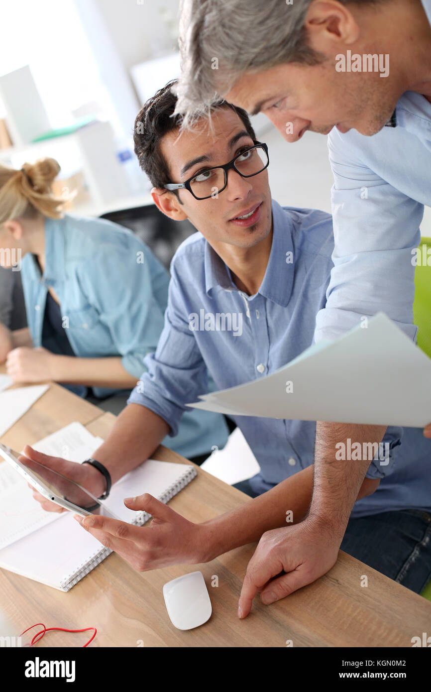 Young man in business training school with teacher Stock Photo - Alamy