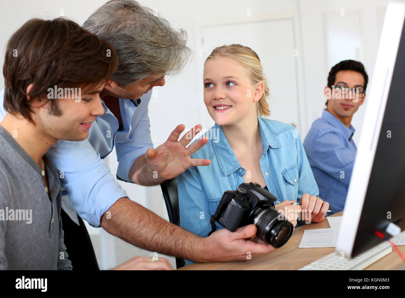 Teacher in class of photography with students Stock Photo - Alamy