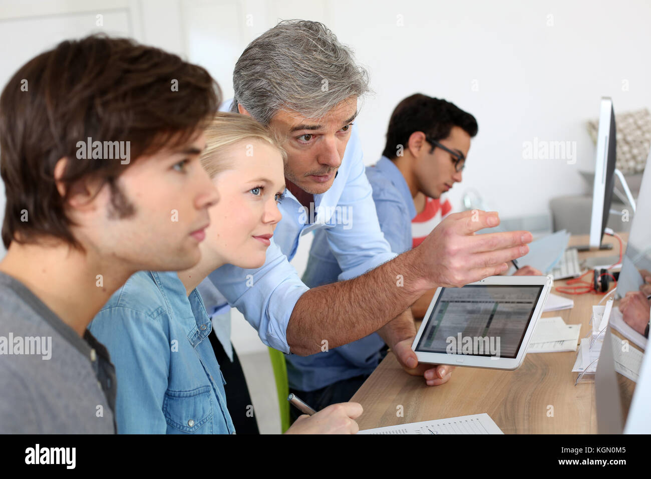 Teacher using digital tablet in school class Stock Photo - Alamy