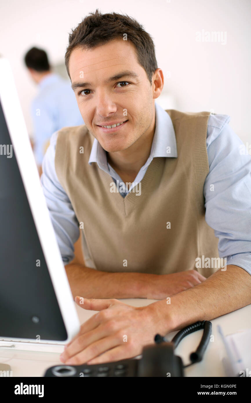 Man working in office in front of desktop computer Stock Photo - Alamy