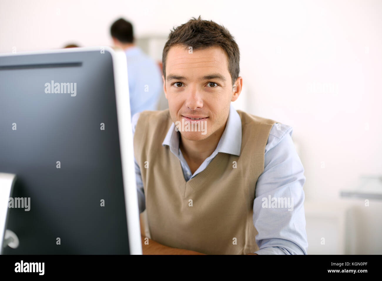 Man working in office in front of desktop computer Stock Photo - Alamy