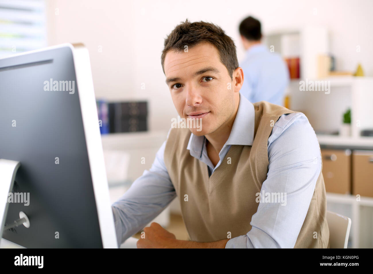 Man working in office in front of desktop computer Stock Photo - Alamy