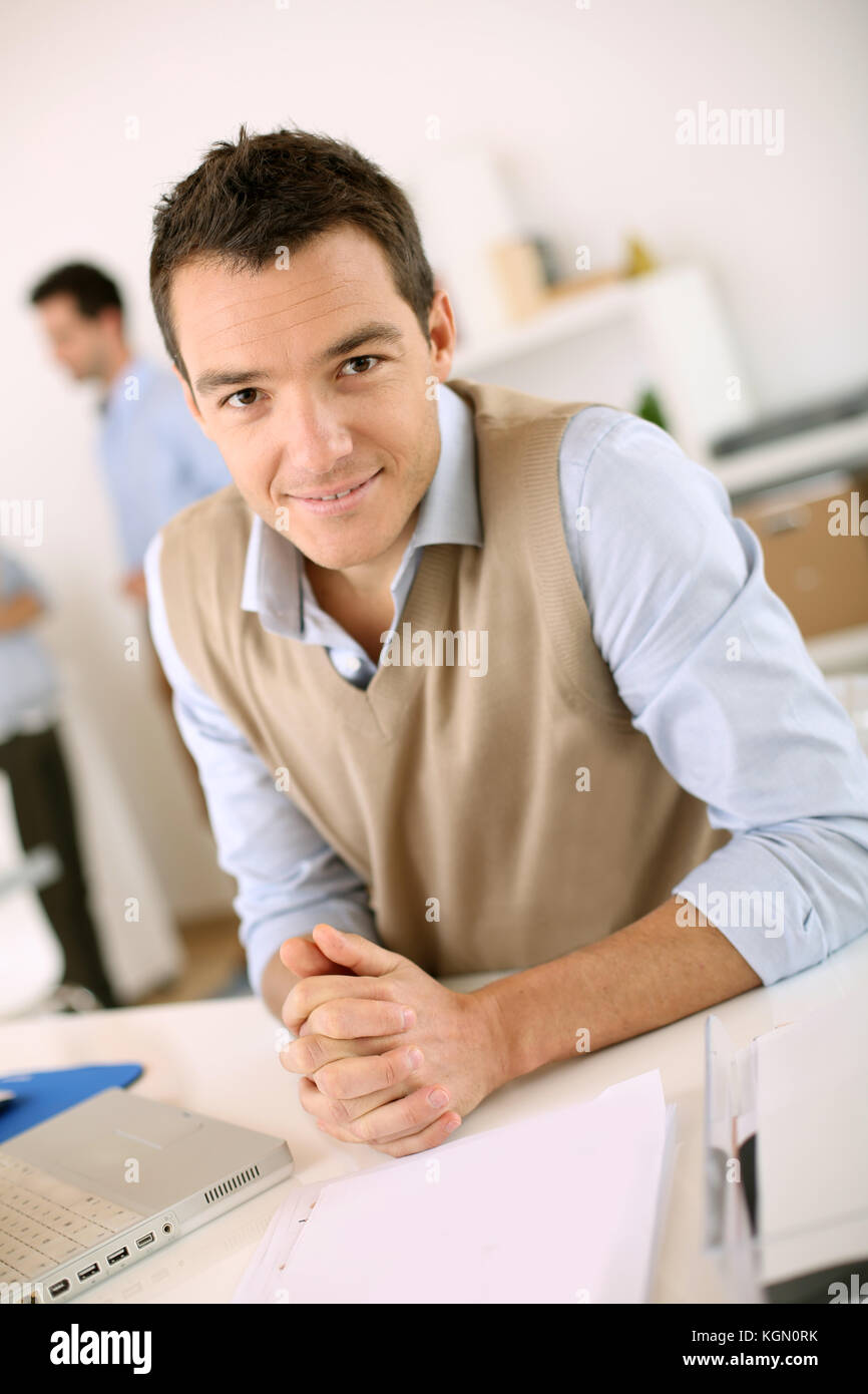 Portrait of smiling man sitting in office Stock Photo - Alamy