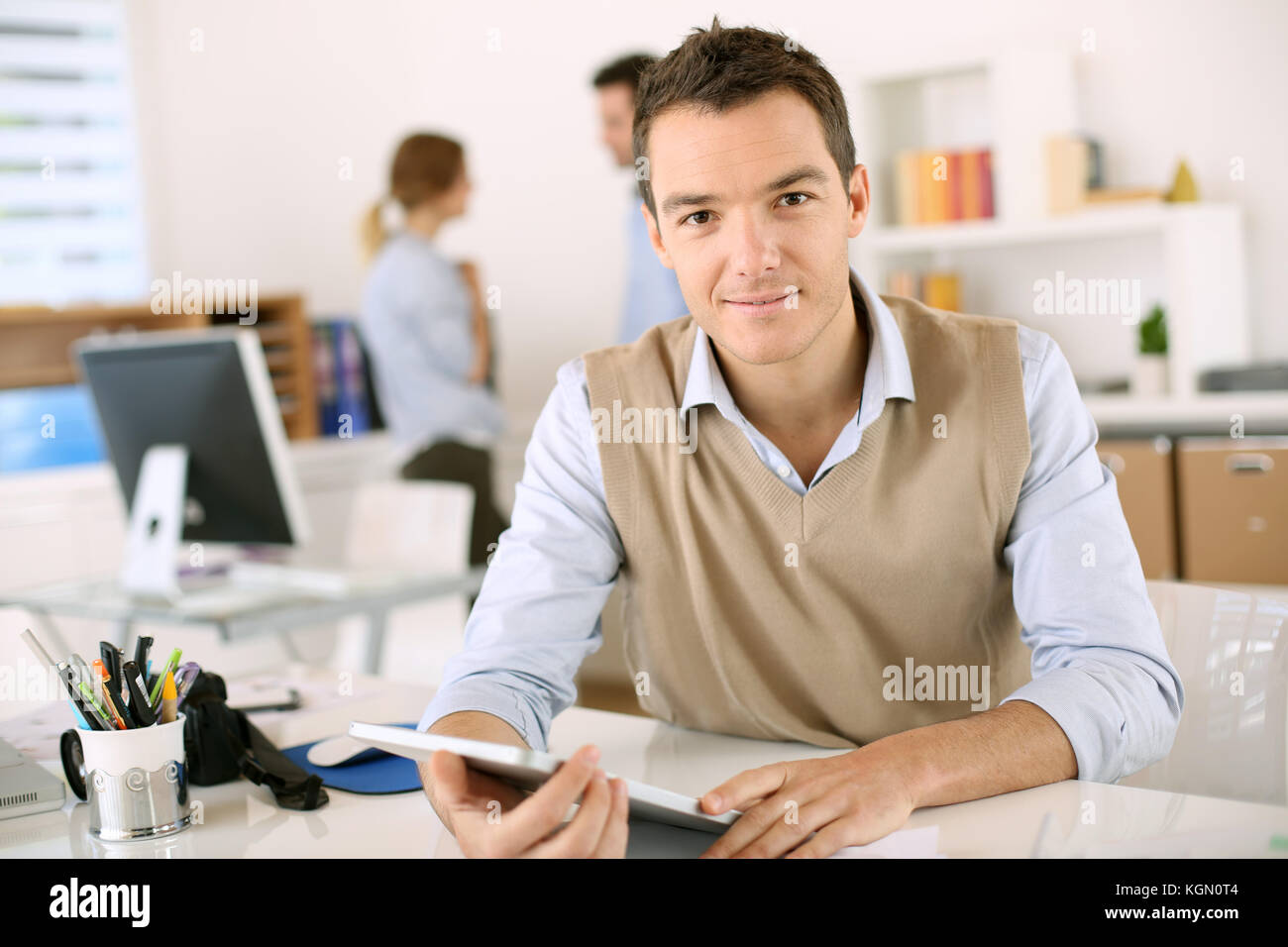 Handsome guy working with tablet in office Stock Photo - Alamy