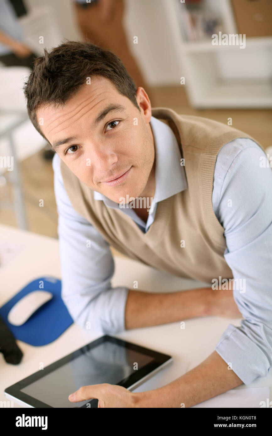 Handsome guy working with tablet in office Stock Photo - Alamy