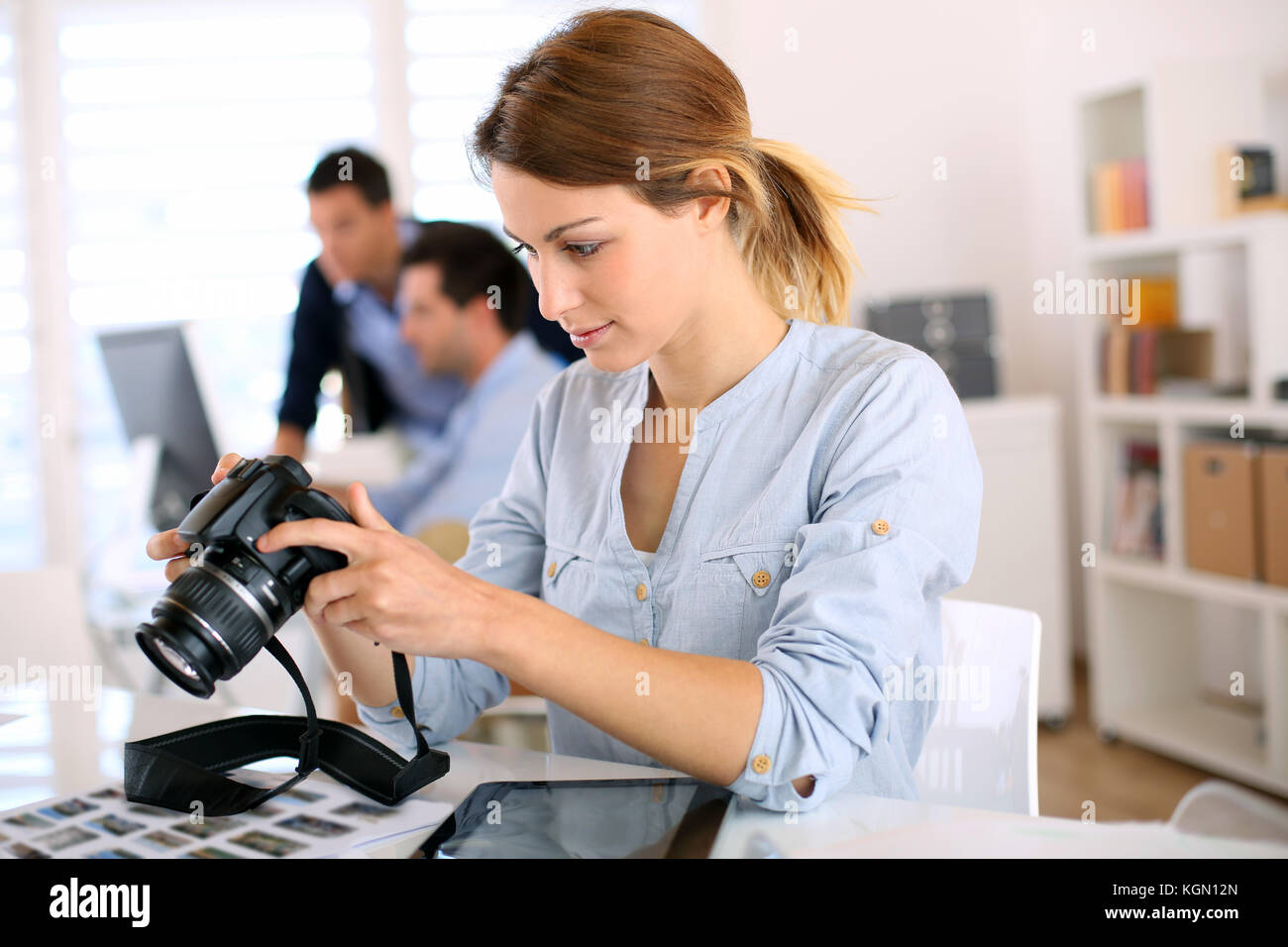 Young photo reporter working in office Stock Photo - Alamy