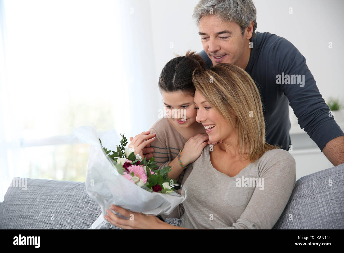 Family celebrating mother's day with bunch of flowers Stock Photo - Alamy