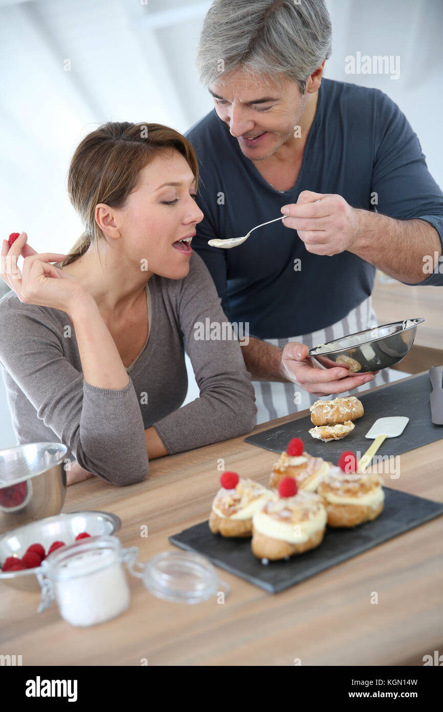 Man having his wife tasting cake preparation Stock Photo - Alamy