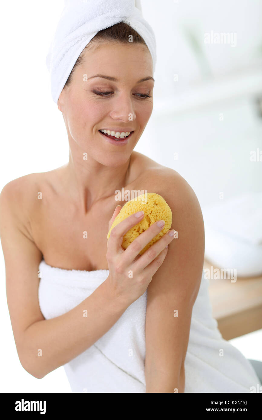 Attractive woman in bathroom using sponge Stock Photo - Alamy