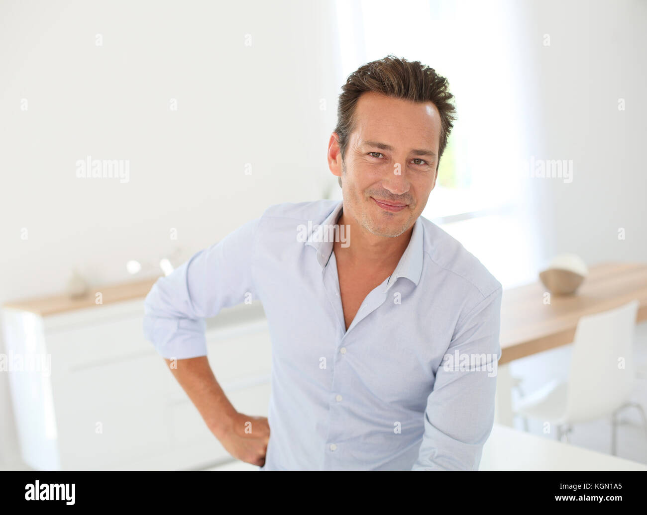 Portrait of handsome man standing at home Stock Photo - Alamy
