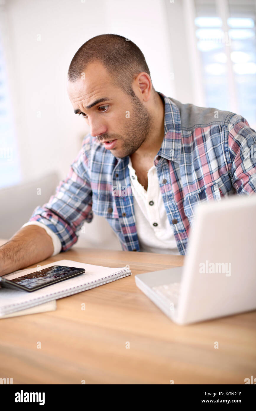 Young man being worried at looking at bank accounts Stock Photo - Alamy