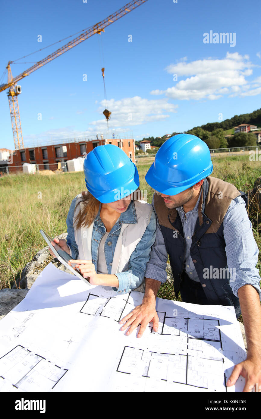 Construction people looking at blueprint Stock Photo - Alamy