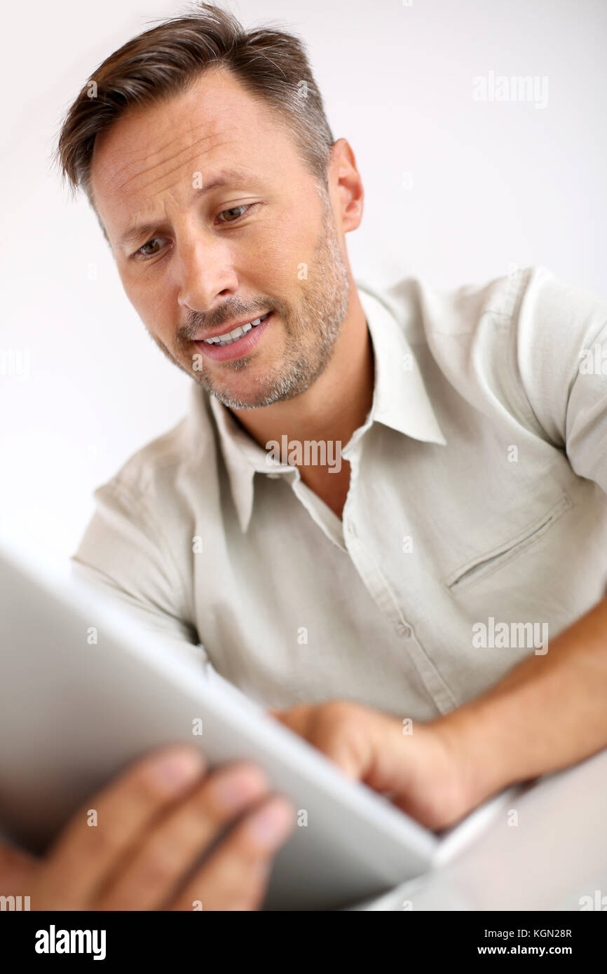 Handsome guy websurfing on internet with tablet Stock Photo - Alamy