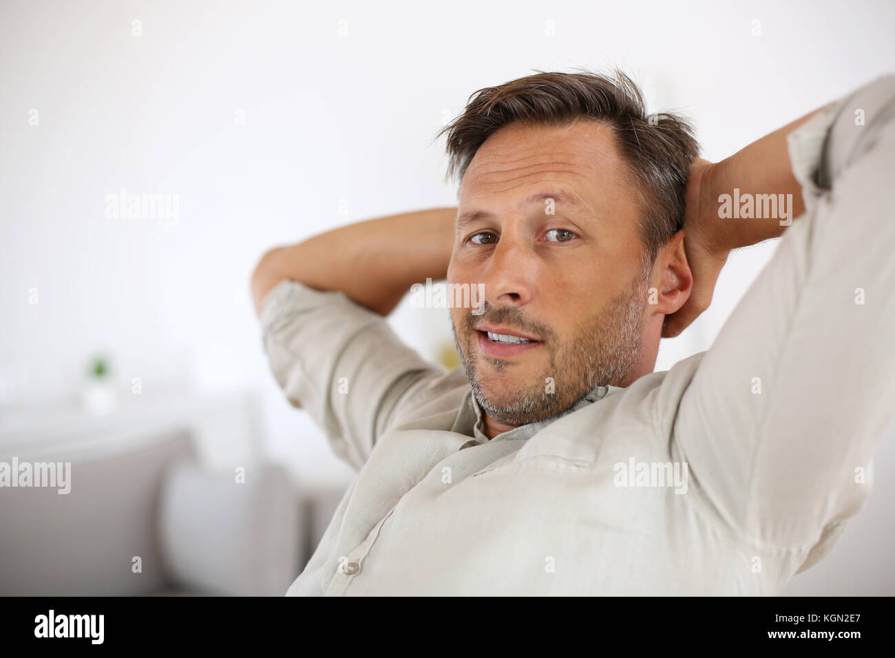 Man relaxing with outstretched arms behind head Stock Photo - Alamy