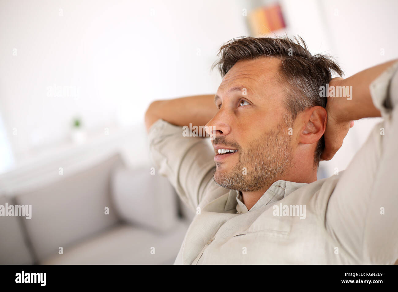 Man relaxing with outstretched arms behind head Stock Photo - Alamy