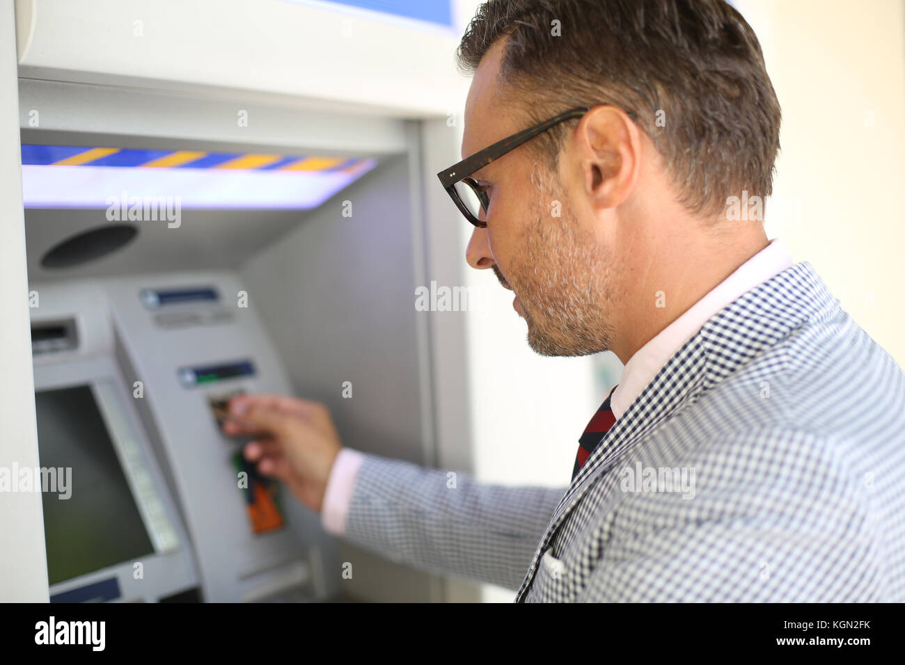 Man withdrawing money from ATM machine Stock Photo - Alamy