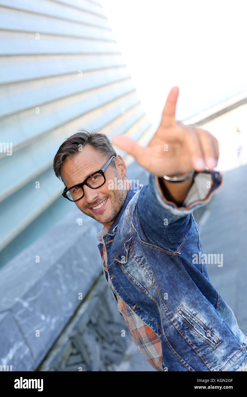 Cheerful trendy guy pointing at camera Stock Photo - Alamy