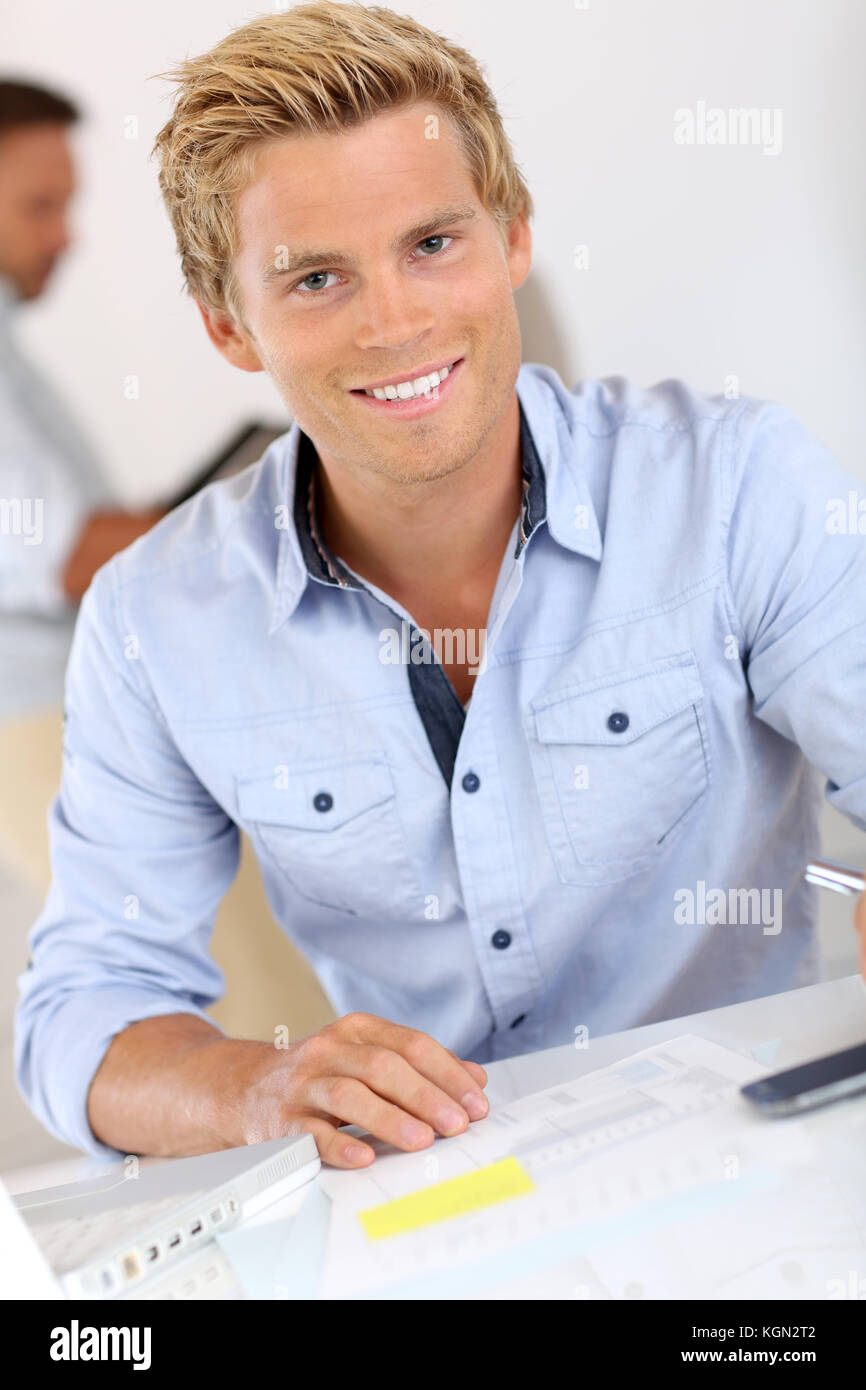 Portrait of smiling attractive young man in office Stock Photo - Alamy